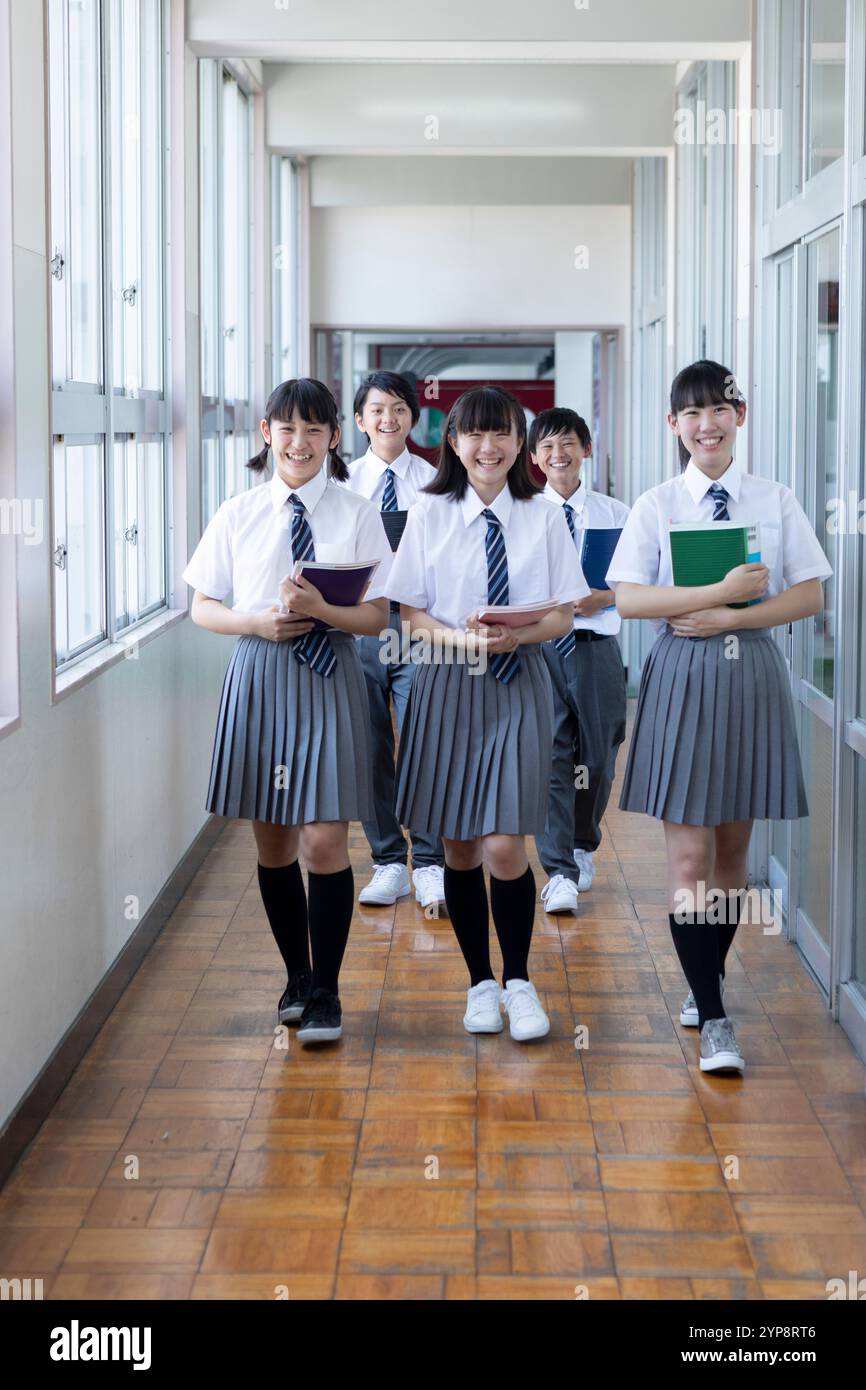 Junior high school students walking in corridor Stock Photo - Alamy