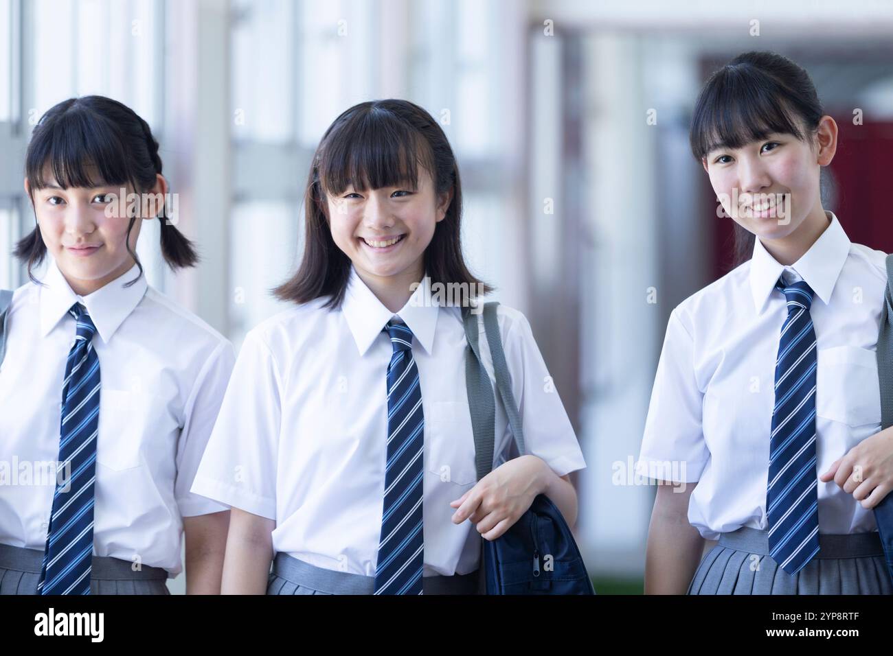 Junior high school students walking side by side down corridor Stock ...