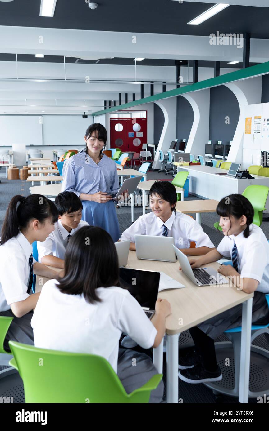 Junior high school students doing group work Stock Photo - Alamy