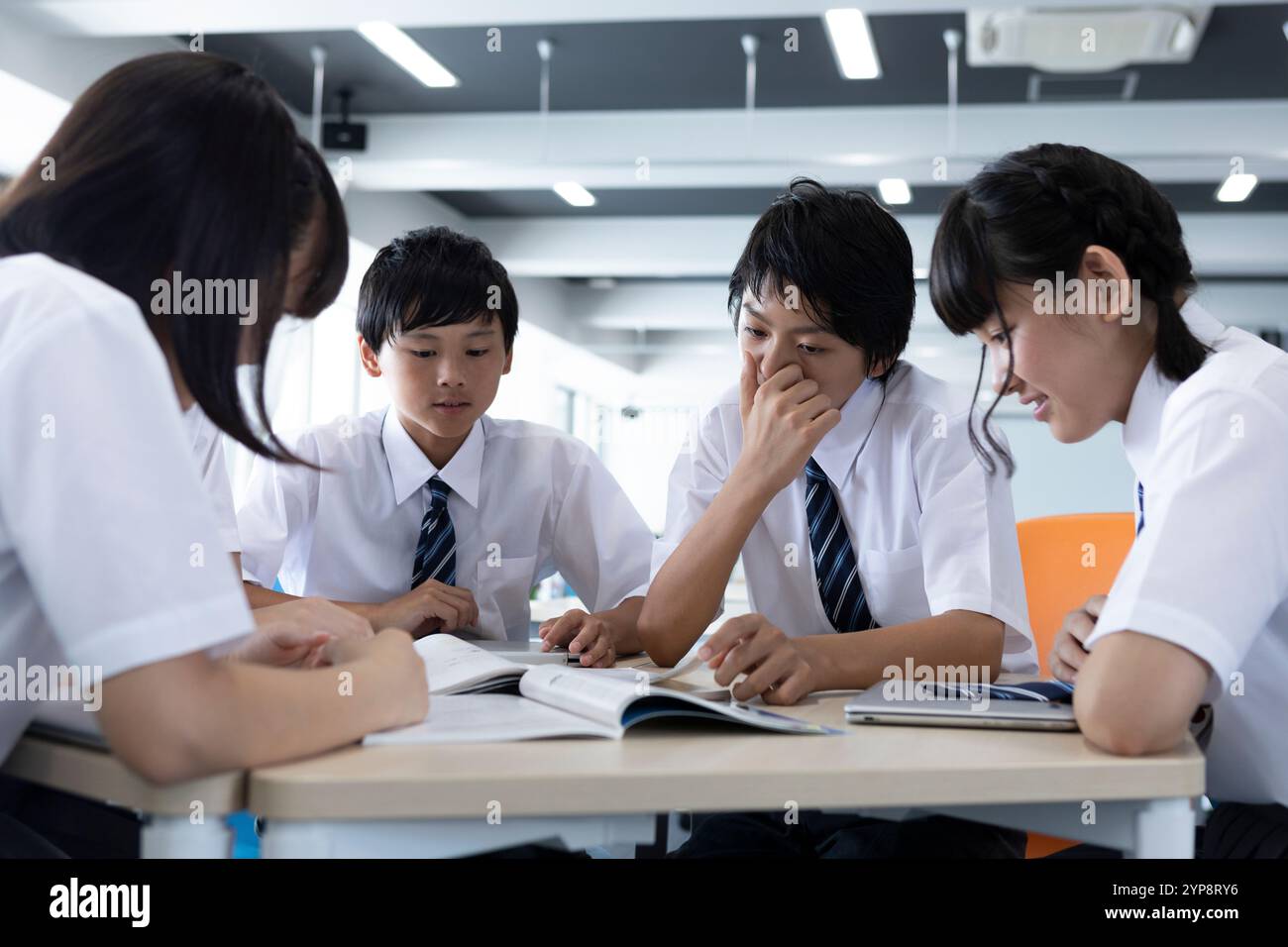 Junior high school students doing group work Stock Photo - Alamy