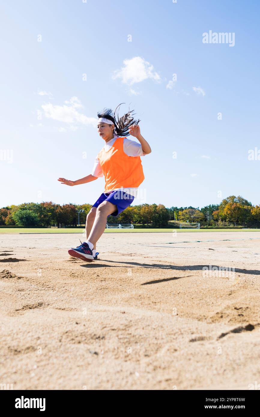 High school students doing the long jump Stock Photo - Alamy