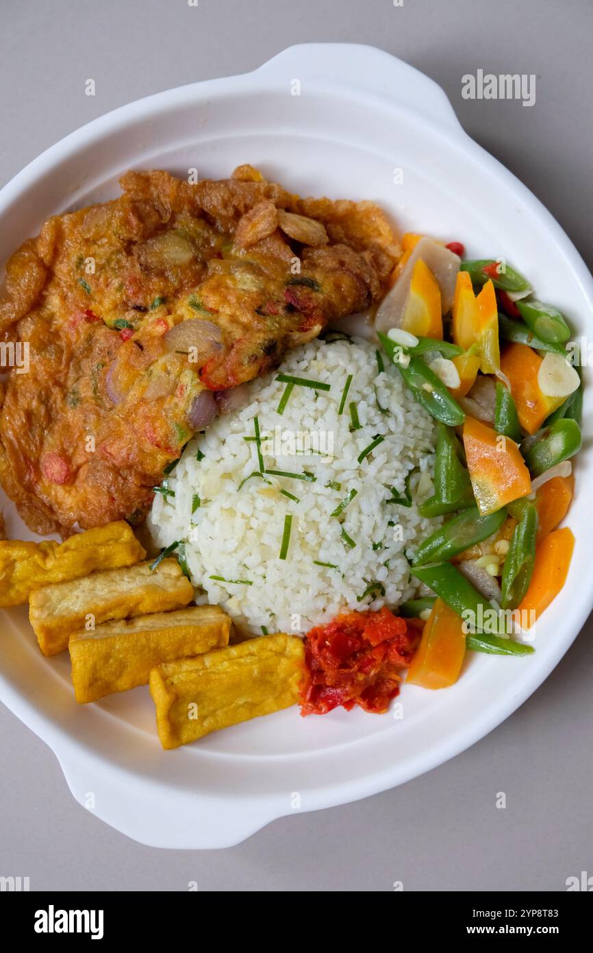 Homemade indonesian food, lime leaf rice served with omelette, stir ...