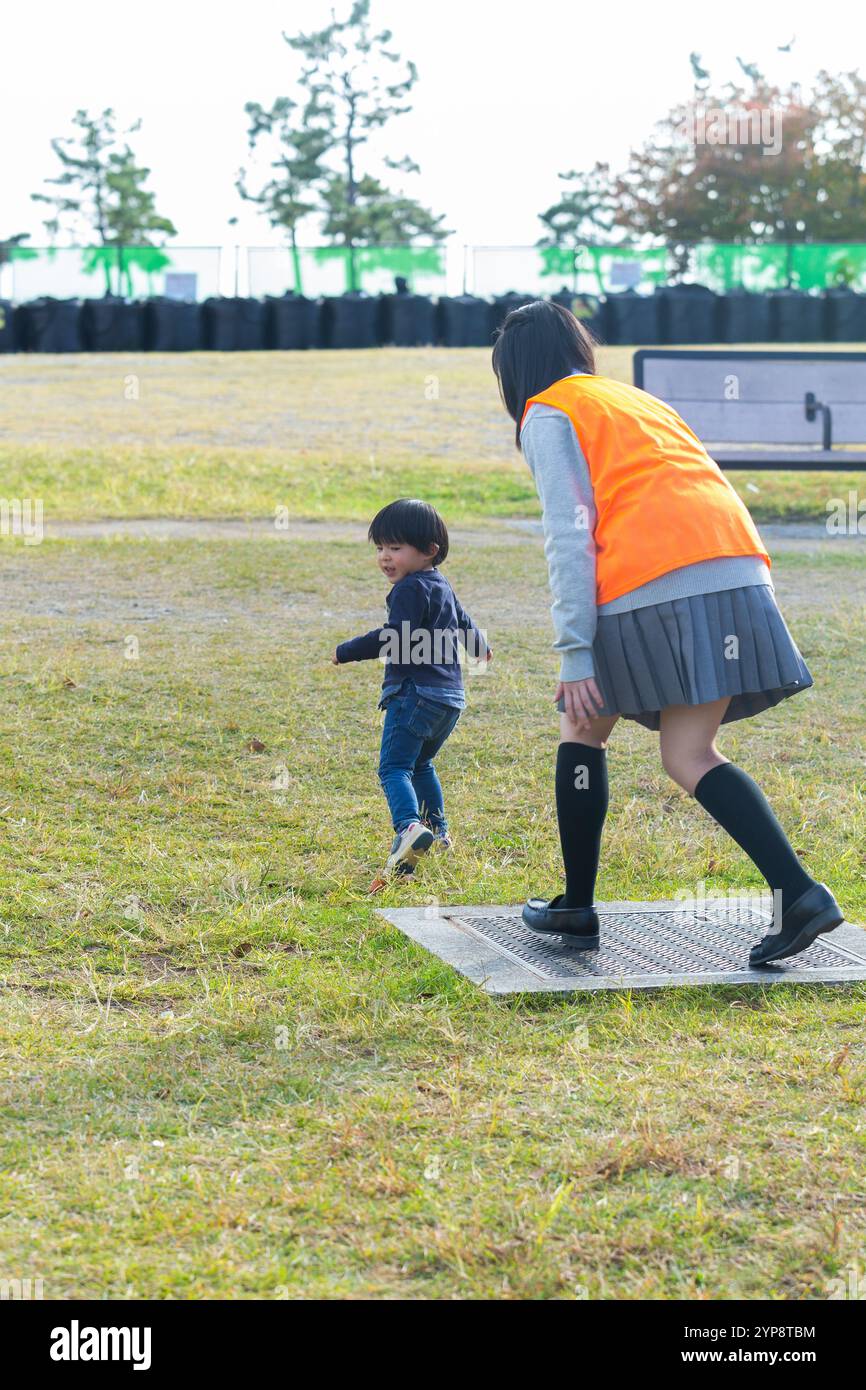 High school students playing with children Stock Photo - Alamy