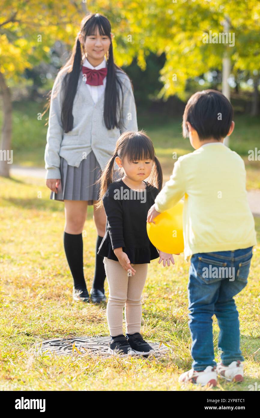 Three children playing ball hi-res stock photography and images - Alamy