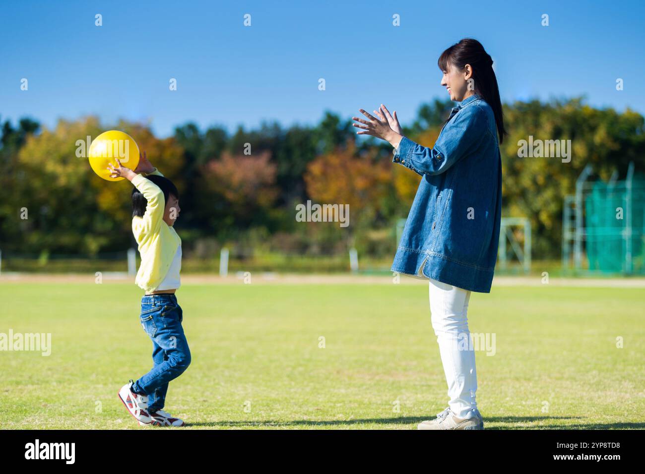 Parents and children playing ball Stock Photo - Alamy