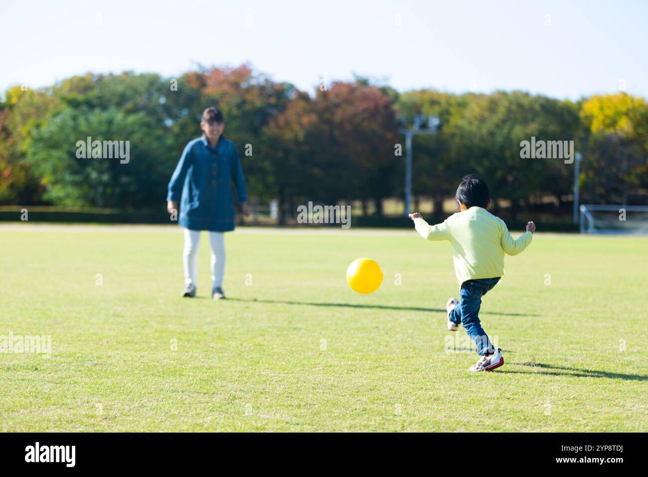 Parents and children playing ball Stock Photo - Alamy