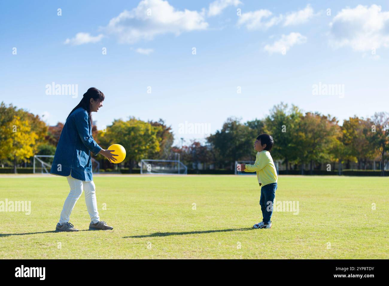 Parents and children playing ball Stock Photo - Alamy