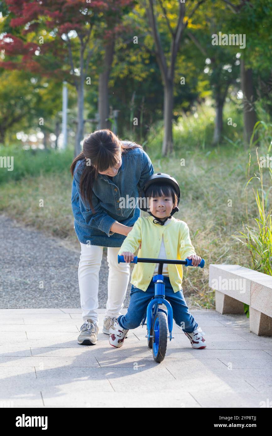 Boy riding kick bike Stock Photo - Alamy