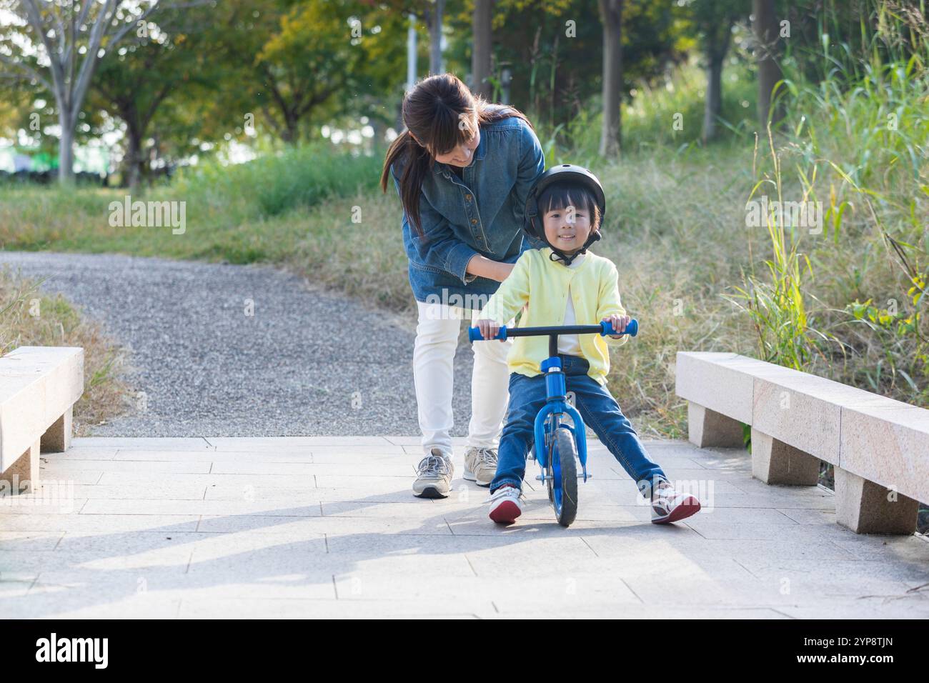 Boy riding kick bike Stock Photo - Alamy