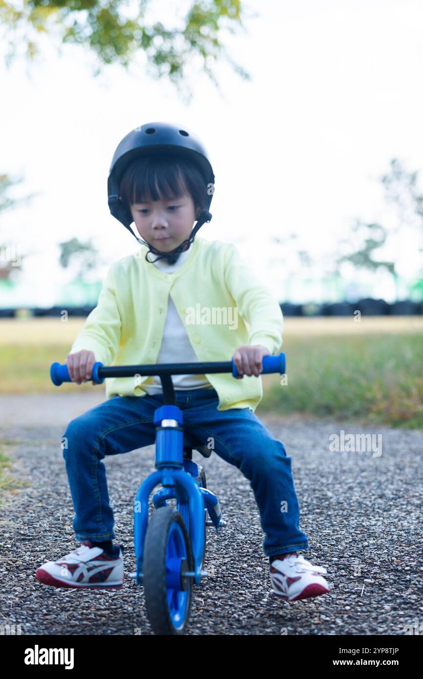 Boy riding kick bike Stock Photo - Alamy