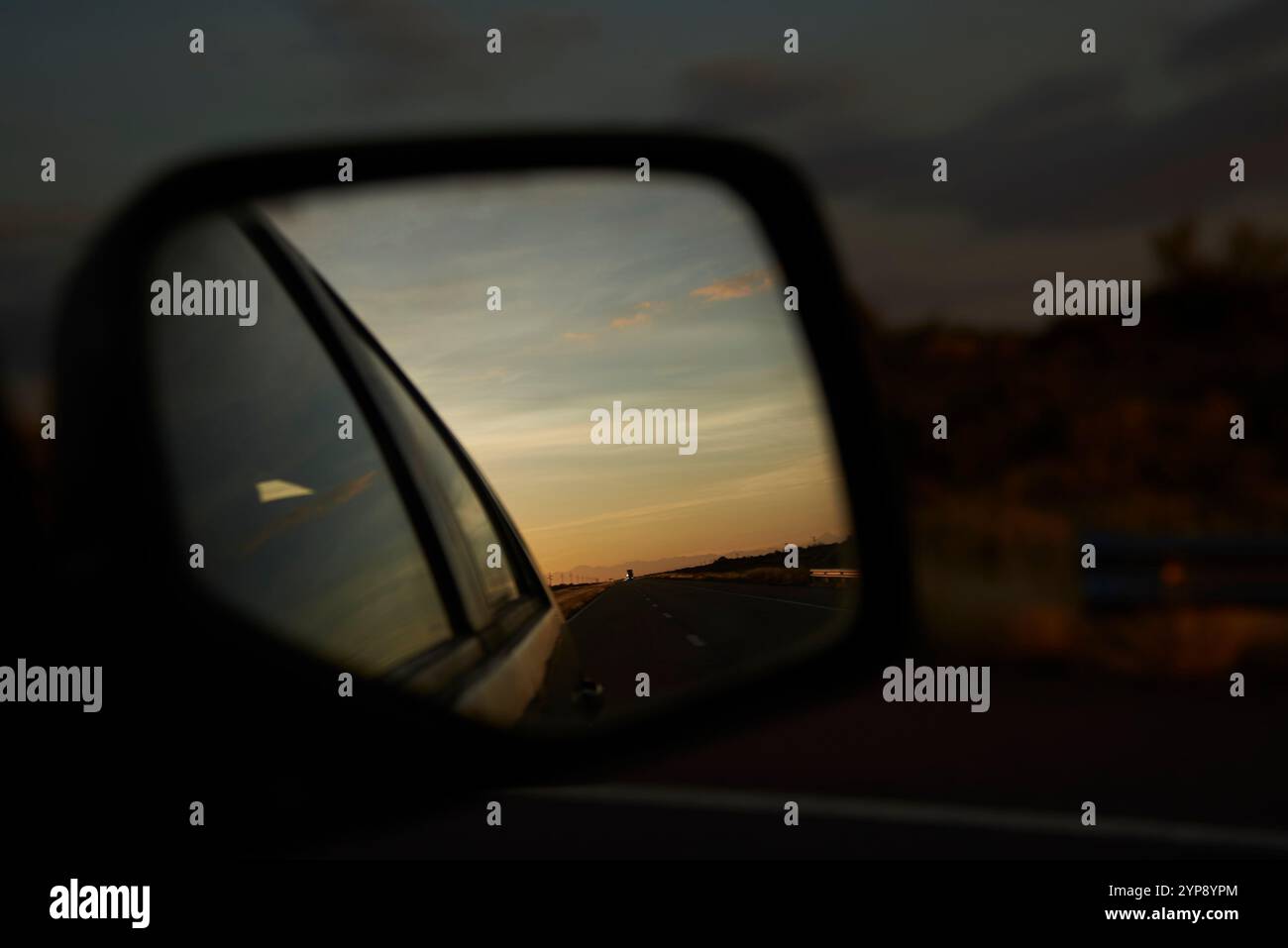 Rear view mirror of a traveling vehicle, in the reflection you can see ...