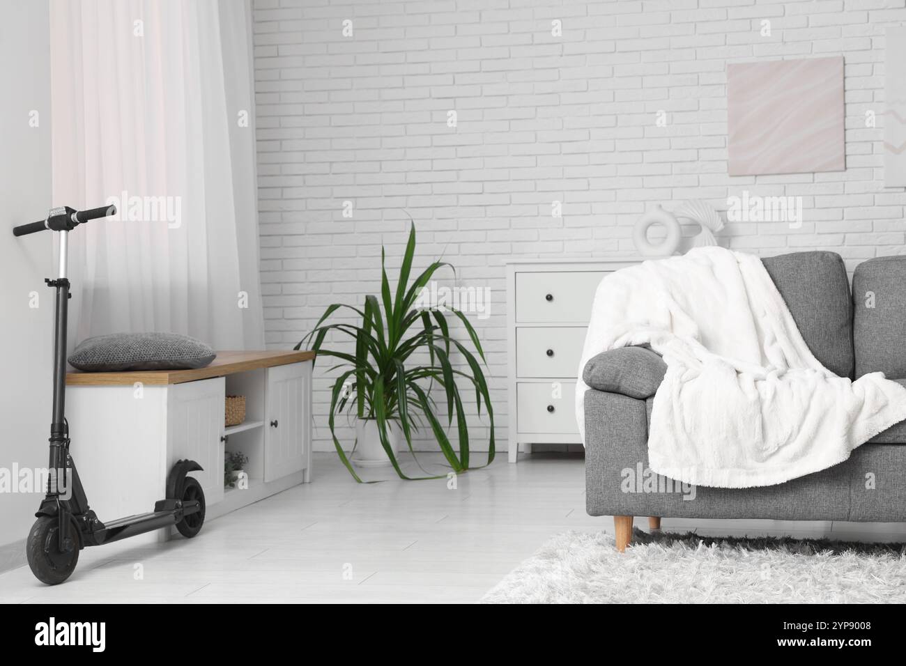 Interior of living room with electric scooter and sofa Stock Photo - Alamy