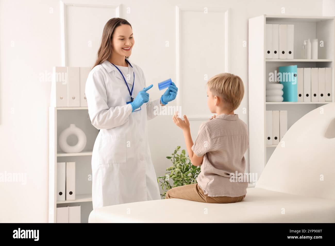 Female doctor with head lice comb and little boy with pediculosis in ...