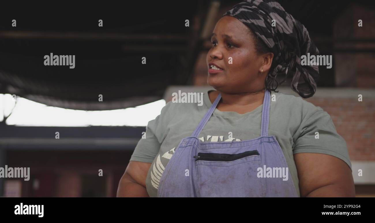Front view of an African female butcher wearing a headscarf in a ...