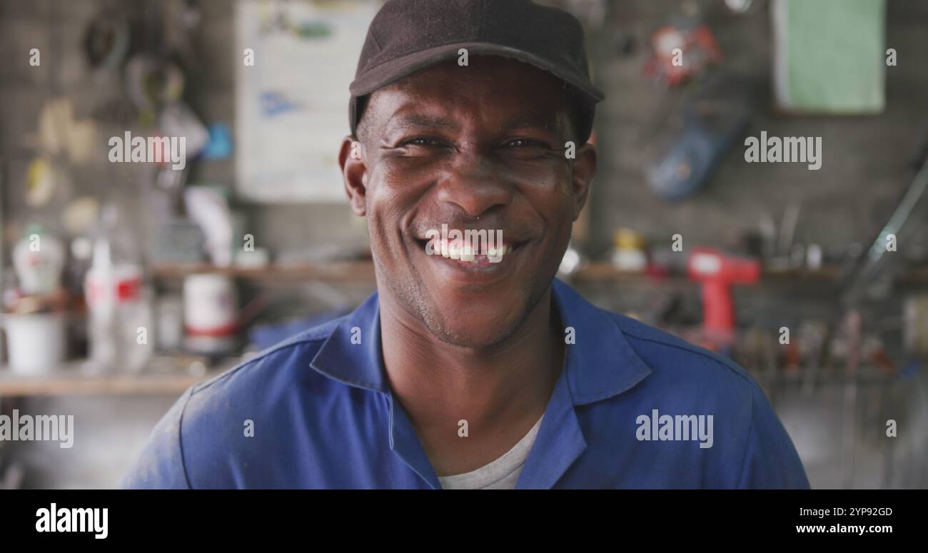 Portrait of a happy African male panel beater in a township workshop ...