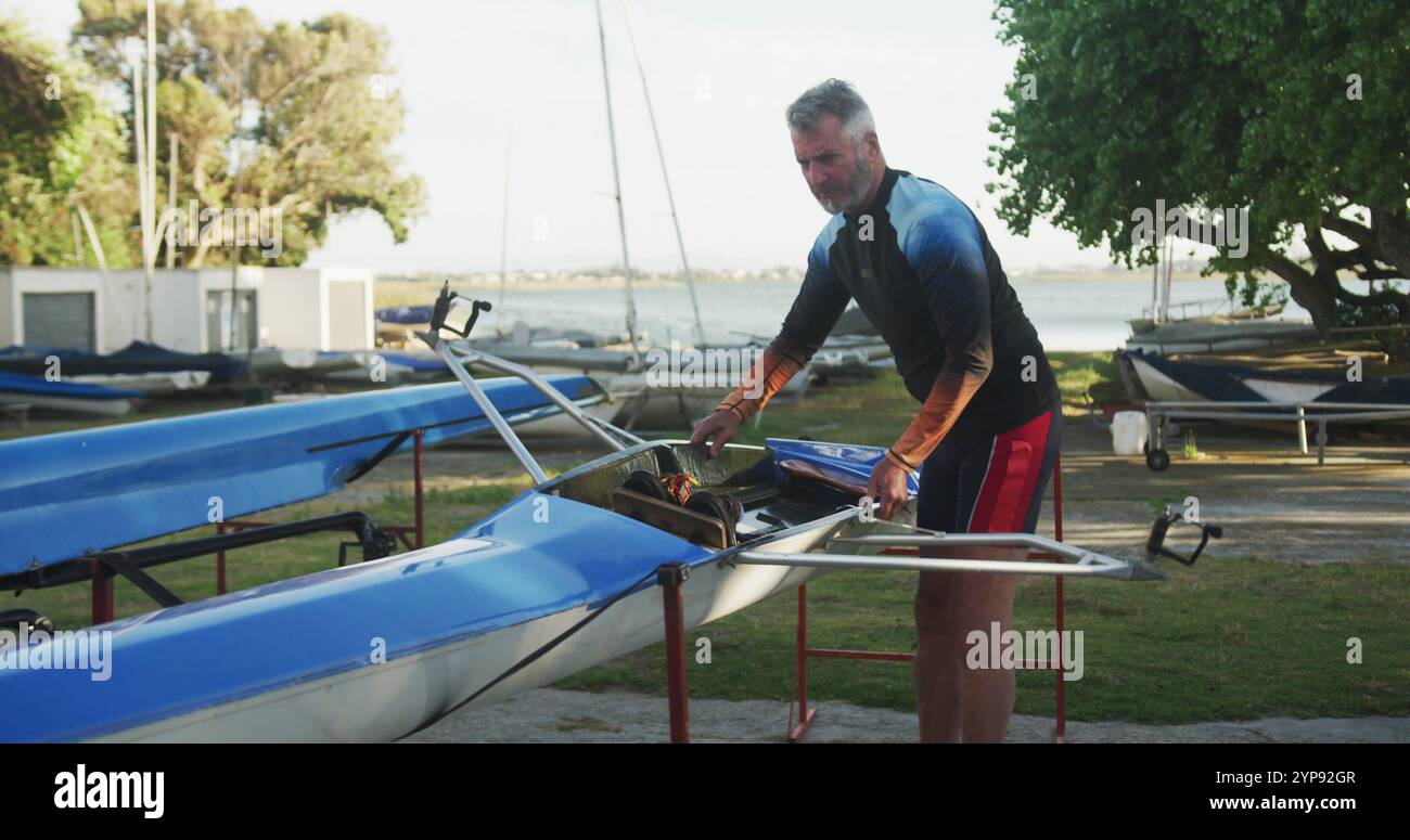 Senior caucasian man preparing rowing boat for the water Stock Photo ...