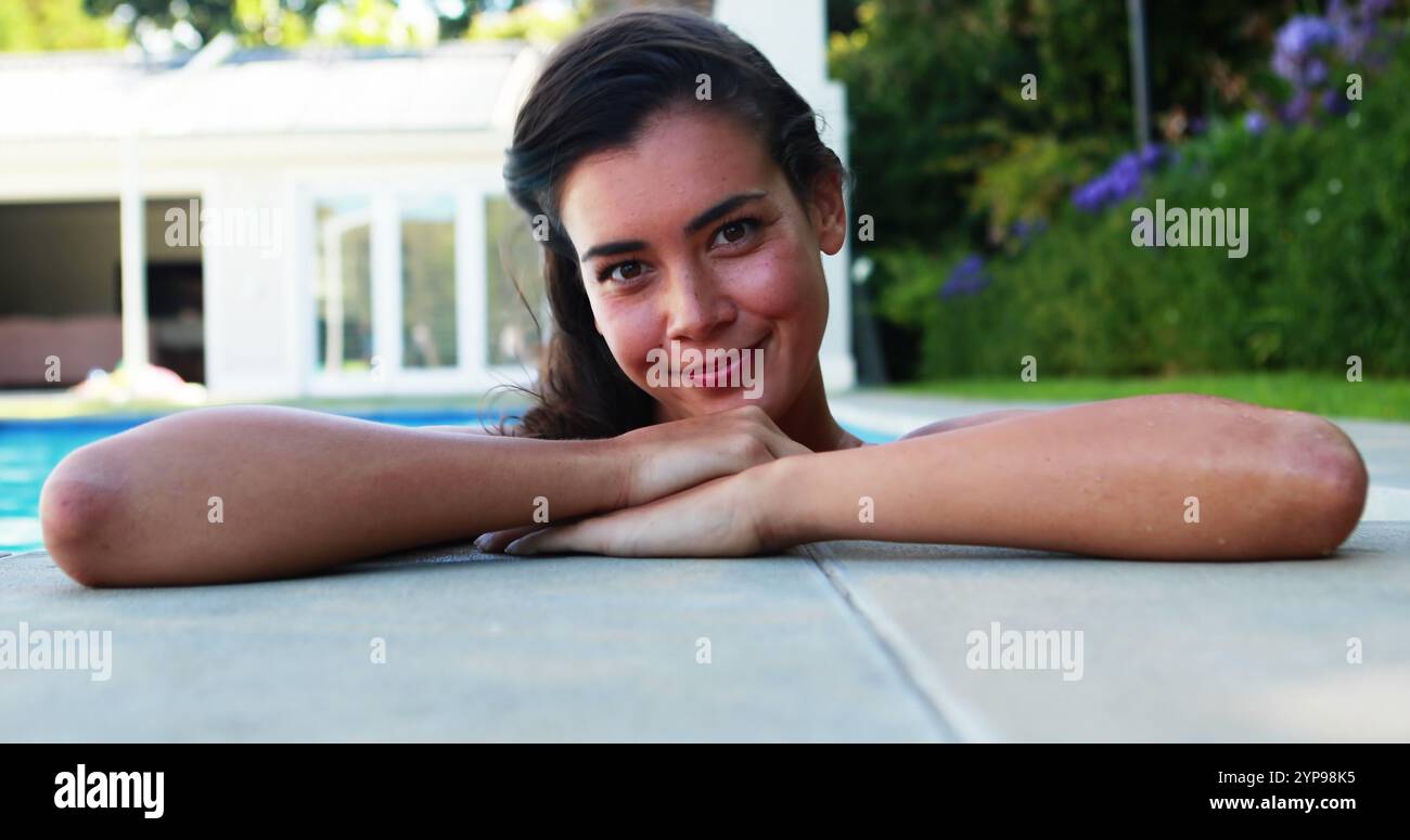 Beautiful woman smiling while leaning over the swimming pool Stock ...