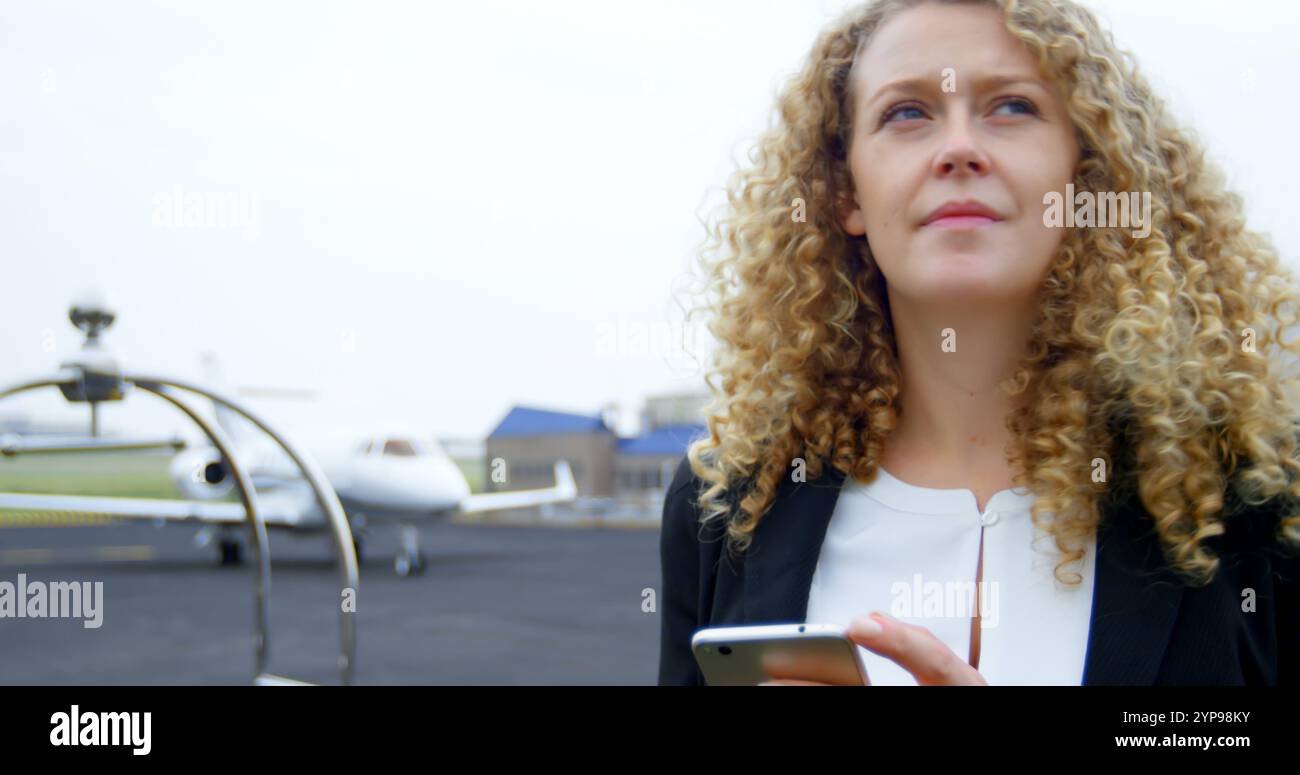 Beautiful businesswoman using mobile phone on a runway 4k Stock Photo ...