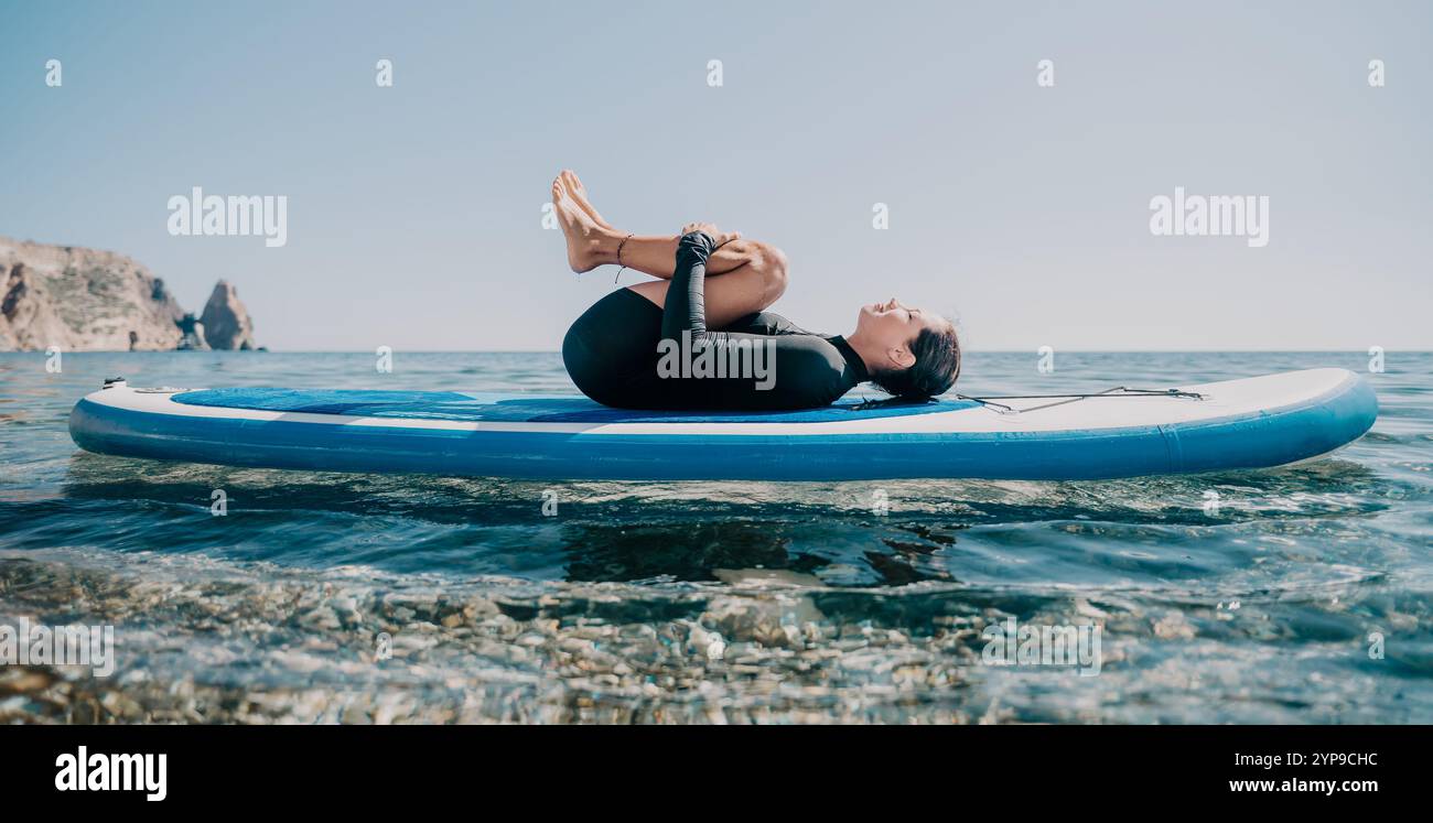 Yoga Paddleboard Beach Woman practicing yoga pose on a paddleboard in ...