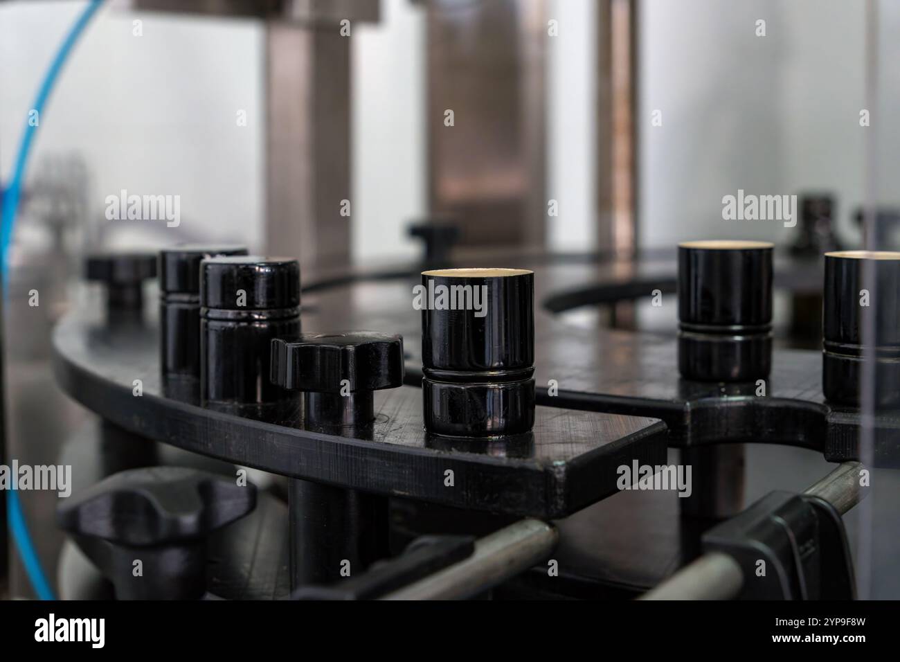 Detail shot of bottle cap alignment mechanism in automated olive oil ...
