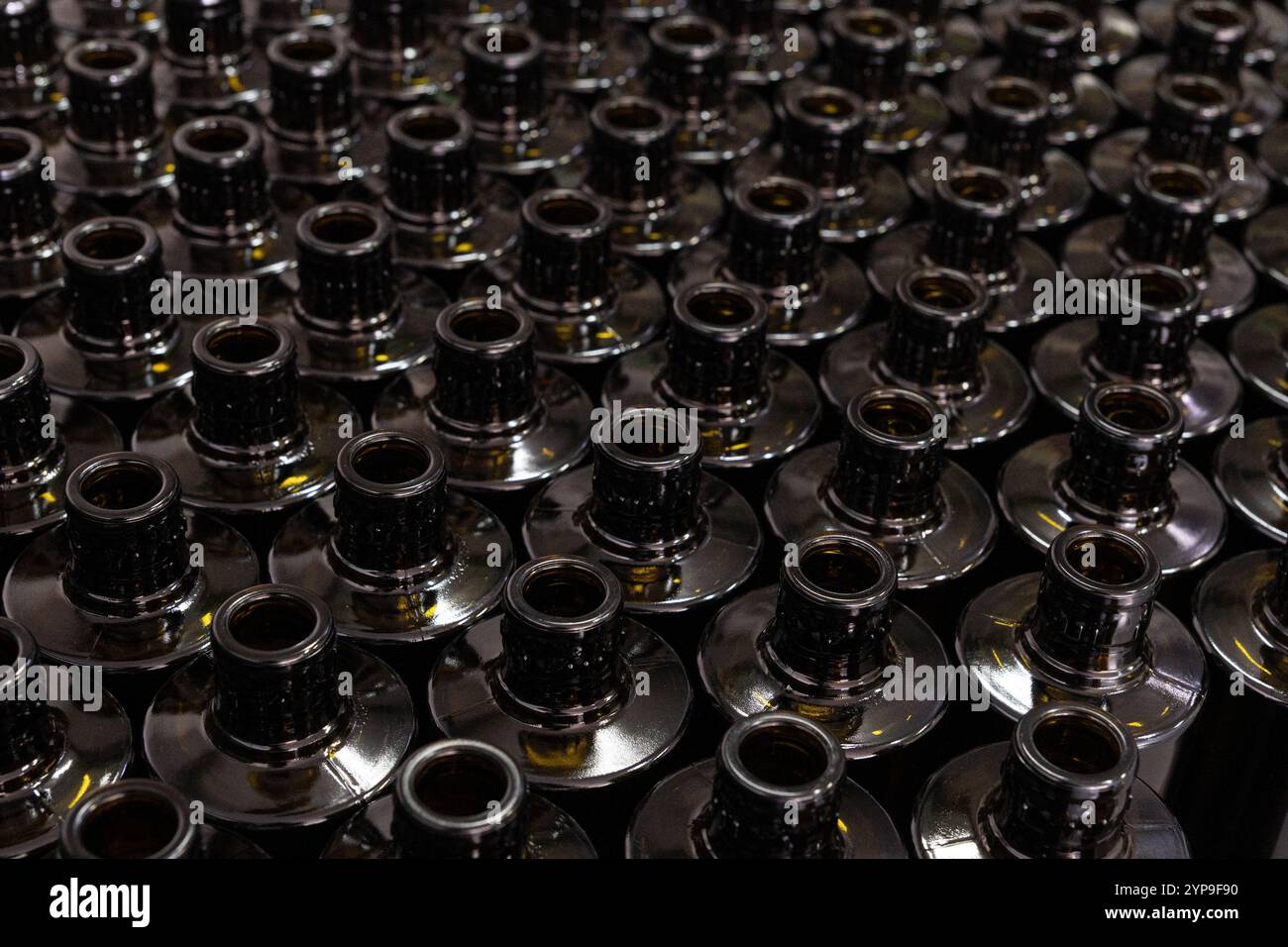 Aerial view of multiple dark glass bottles arranged in industrial ...