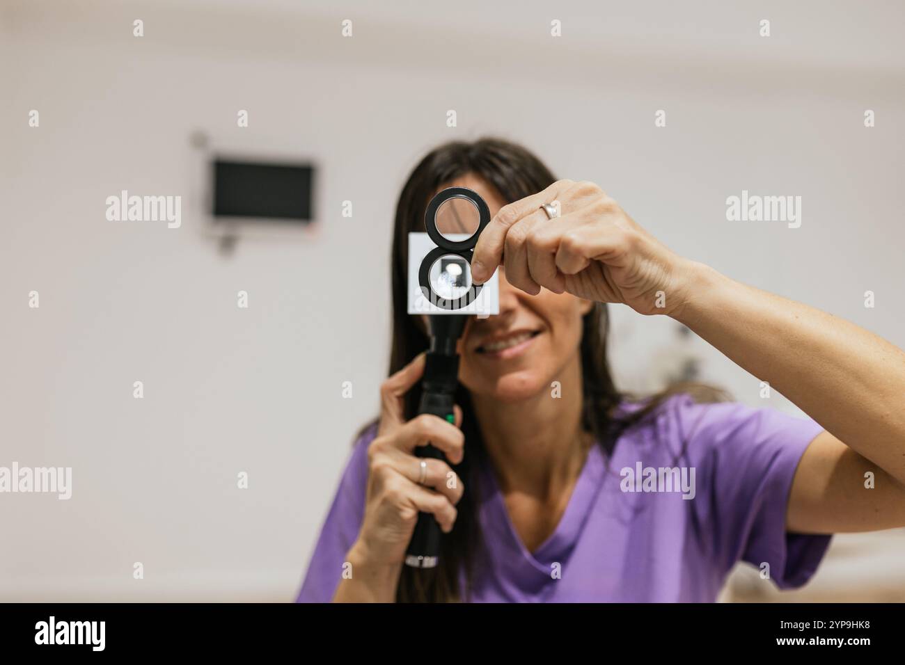 Optometrist performing retinoscopy exam using retinoscope Stock Photo ...