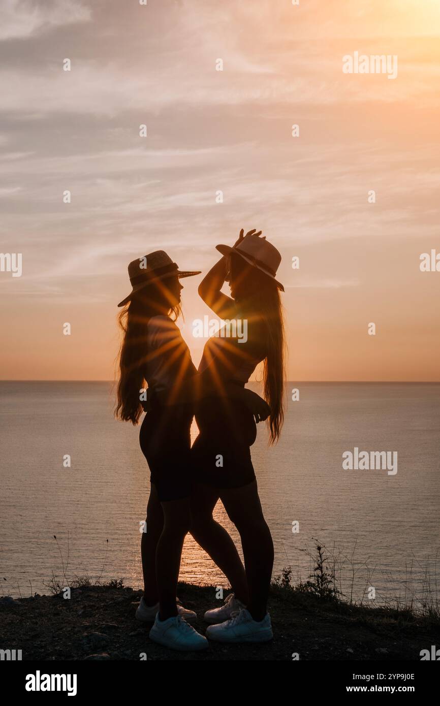 Silhouettes of Two Women in Hats at Sunset Stock Photo - Alamy