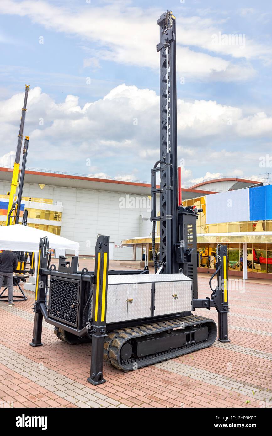 A modern drilling machine stands prominently at a bustling urban ...