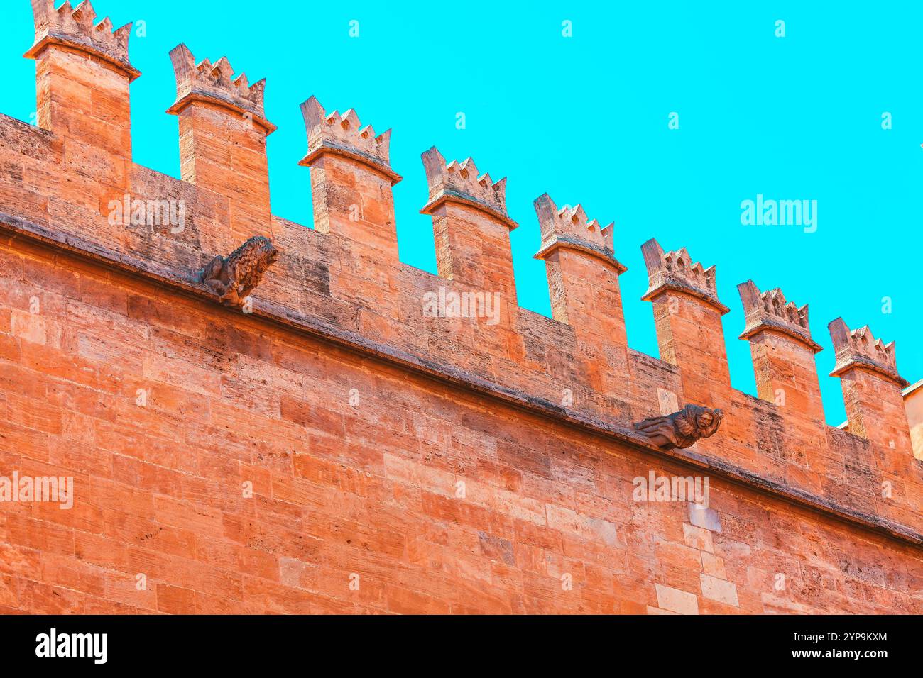 Top section of a historic stone wall with crenellations and two ...