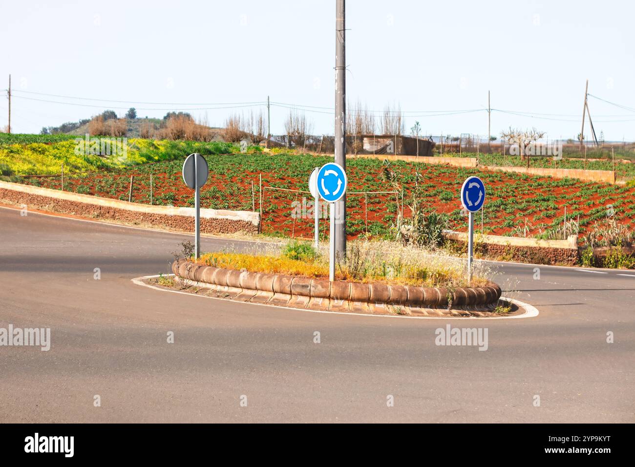 Small roundabout with blue circular traffic signs indicating direction ...