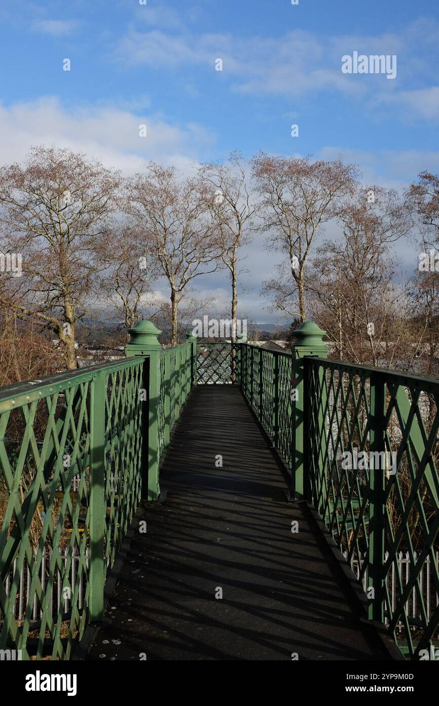 Pretty old footbridge with green painted metal lattice work railing ...