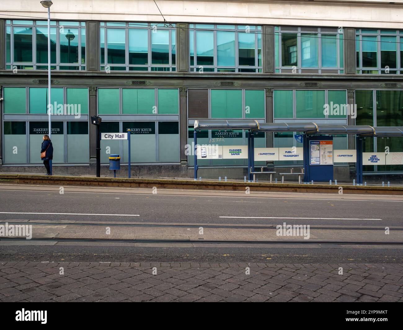Solitary woman waiting at City Hall tram stop on West Street in the ...