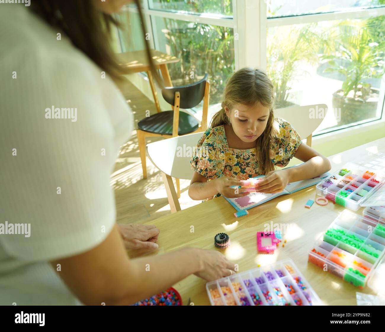Teacher in workshop teched two girls how to assemble a thermo mosaic ...