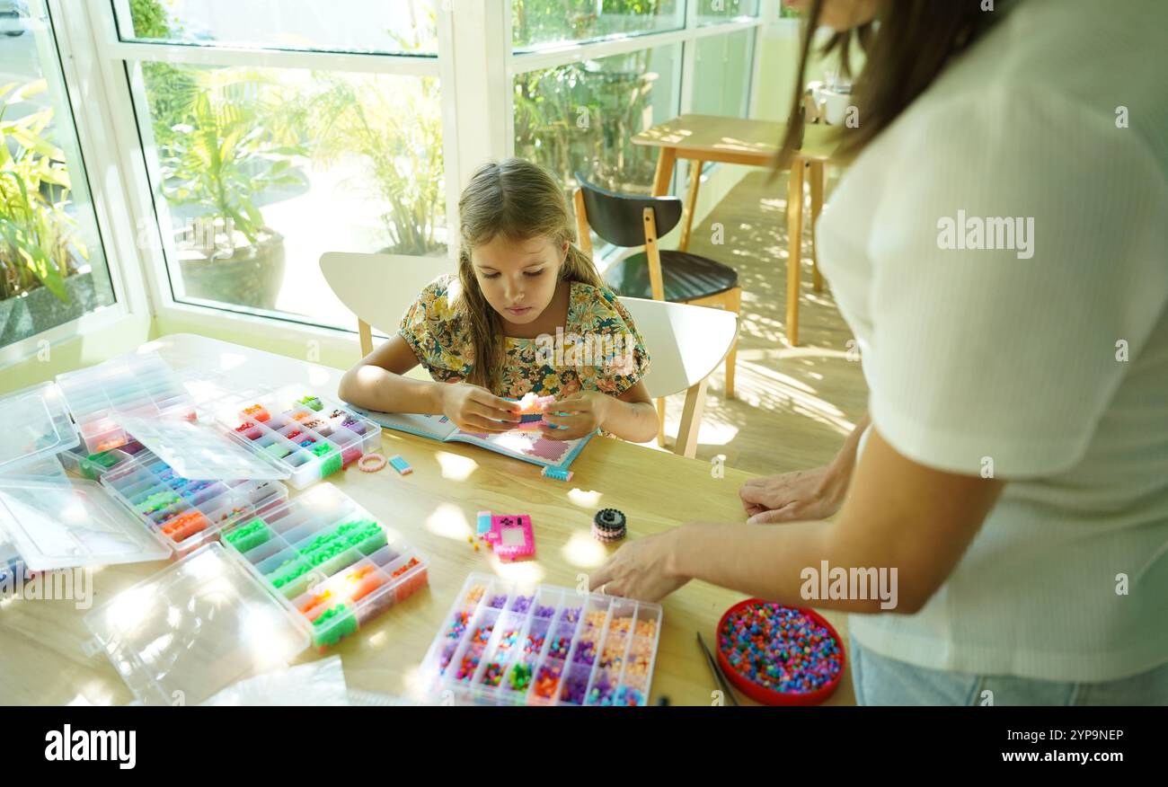 Teacher in workshop teched two girls how to assemble a thermo mosaic ...