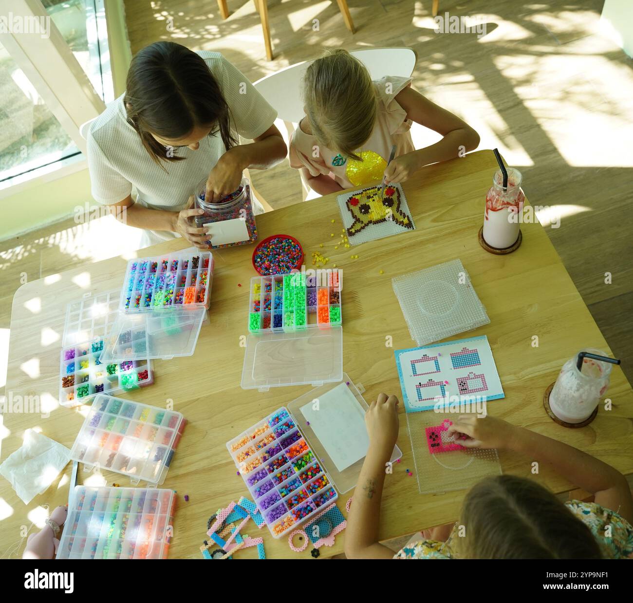 Teacher in workshop teched two girls how to assemble a thermo mosaic ...