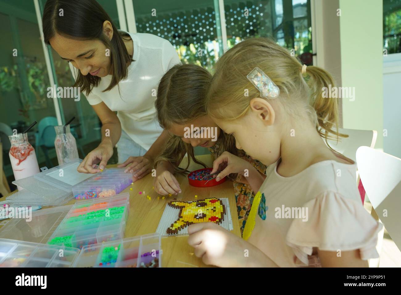 Teacher in workshop teched two girls how to assemble a thermo mosaic ...