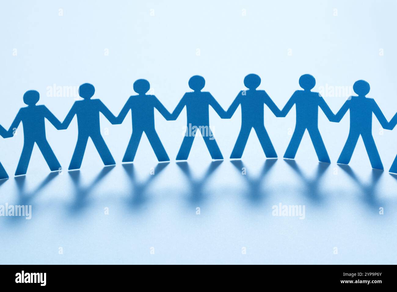 Paper people standing together hand in hand Stock Photo - Alamy
