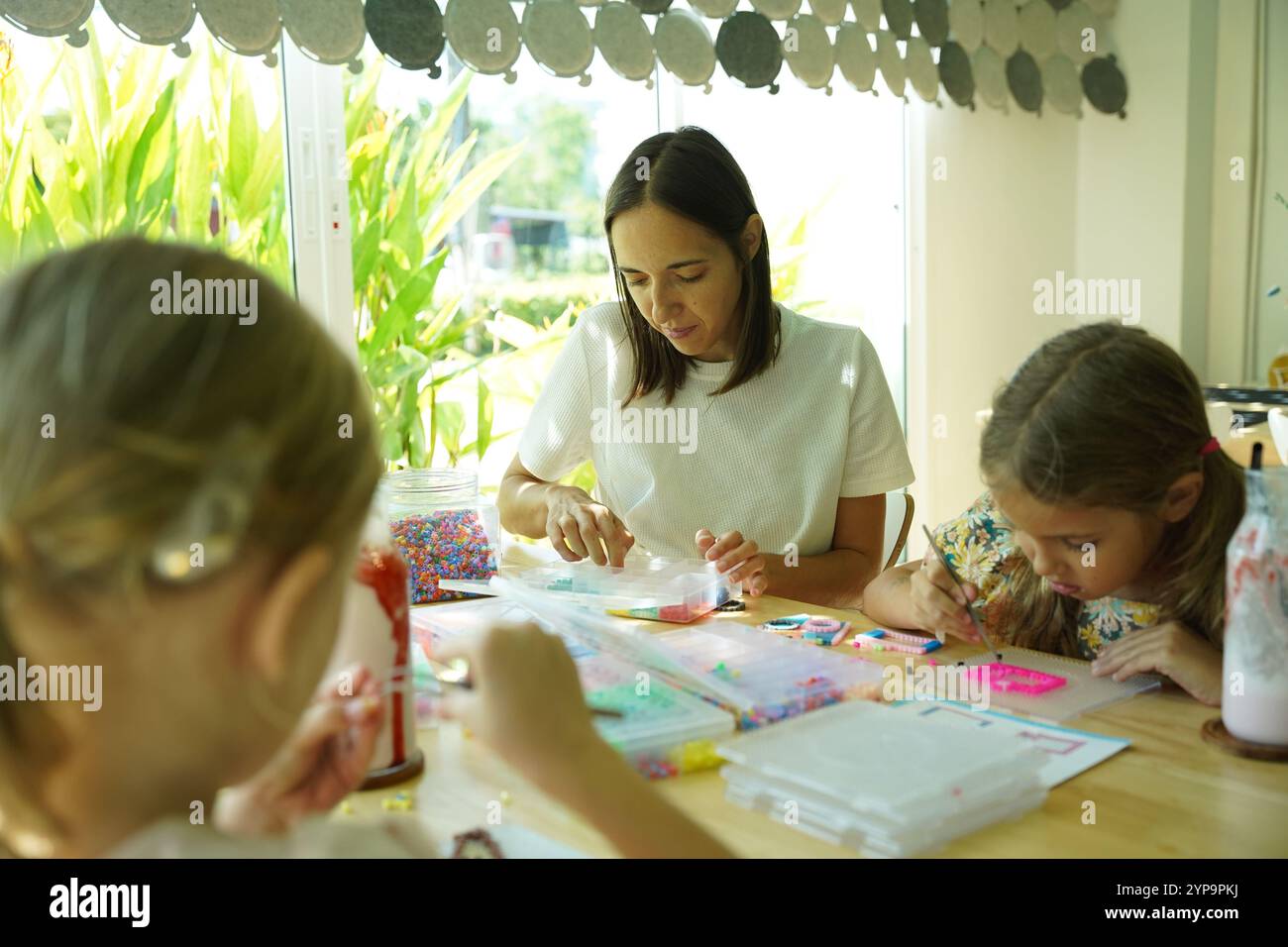 Teacher in workshop teched two girls how to assemble a thermo mosaic ...