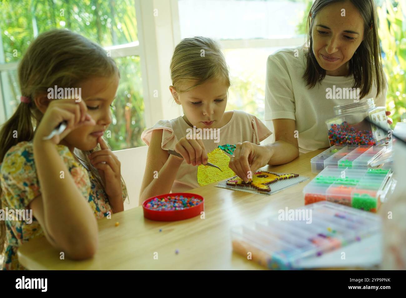 Teacher in workshop teched two girls how to assemble a thermo mosaic ...