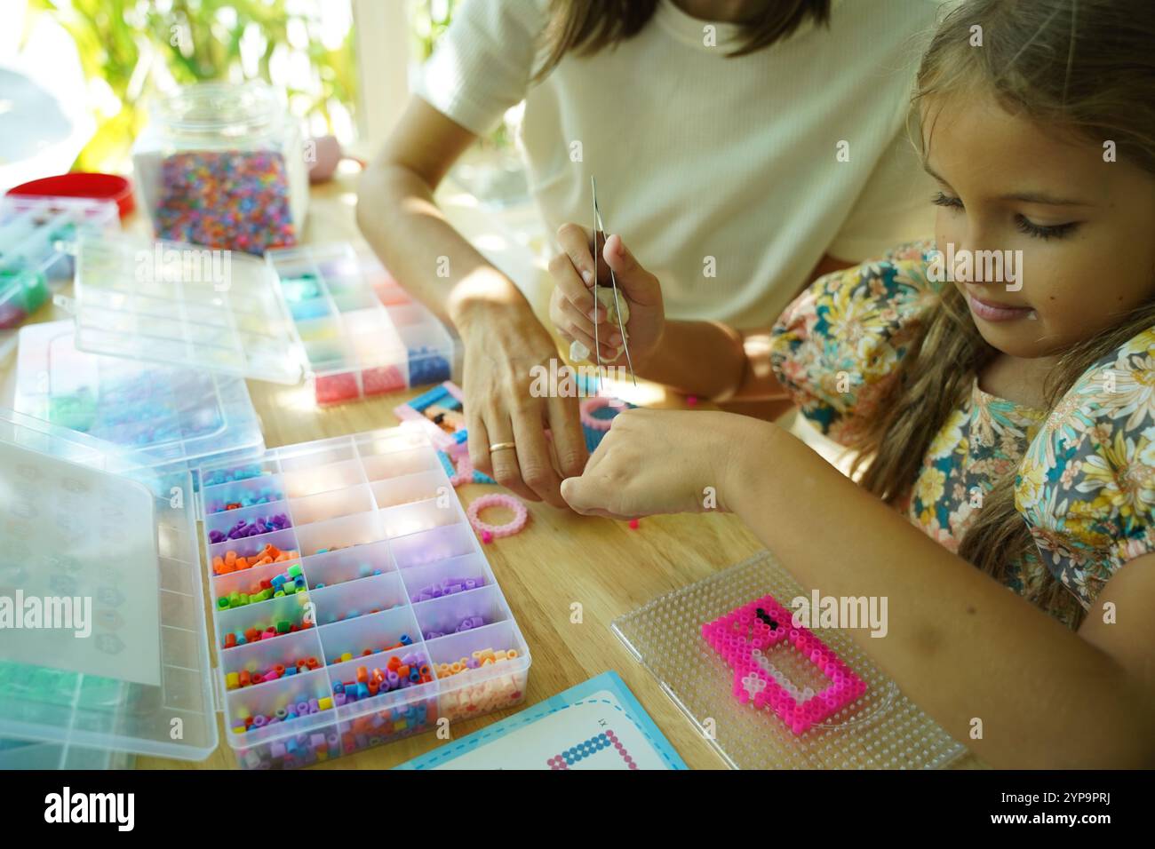 Teacher in workshop teched two girls how to assemble a thermo mosaic ...