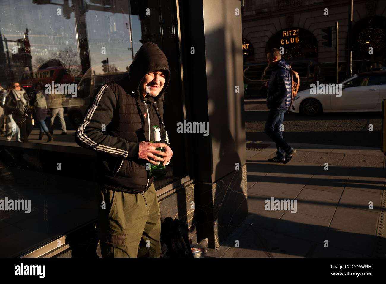 Homeless man holding a bottle of Stella Artois along Piccadilly, London ...