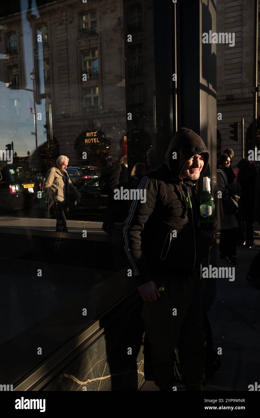 Homeless man holding a bottle of Stella Artois along Piccadilly, London ...