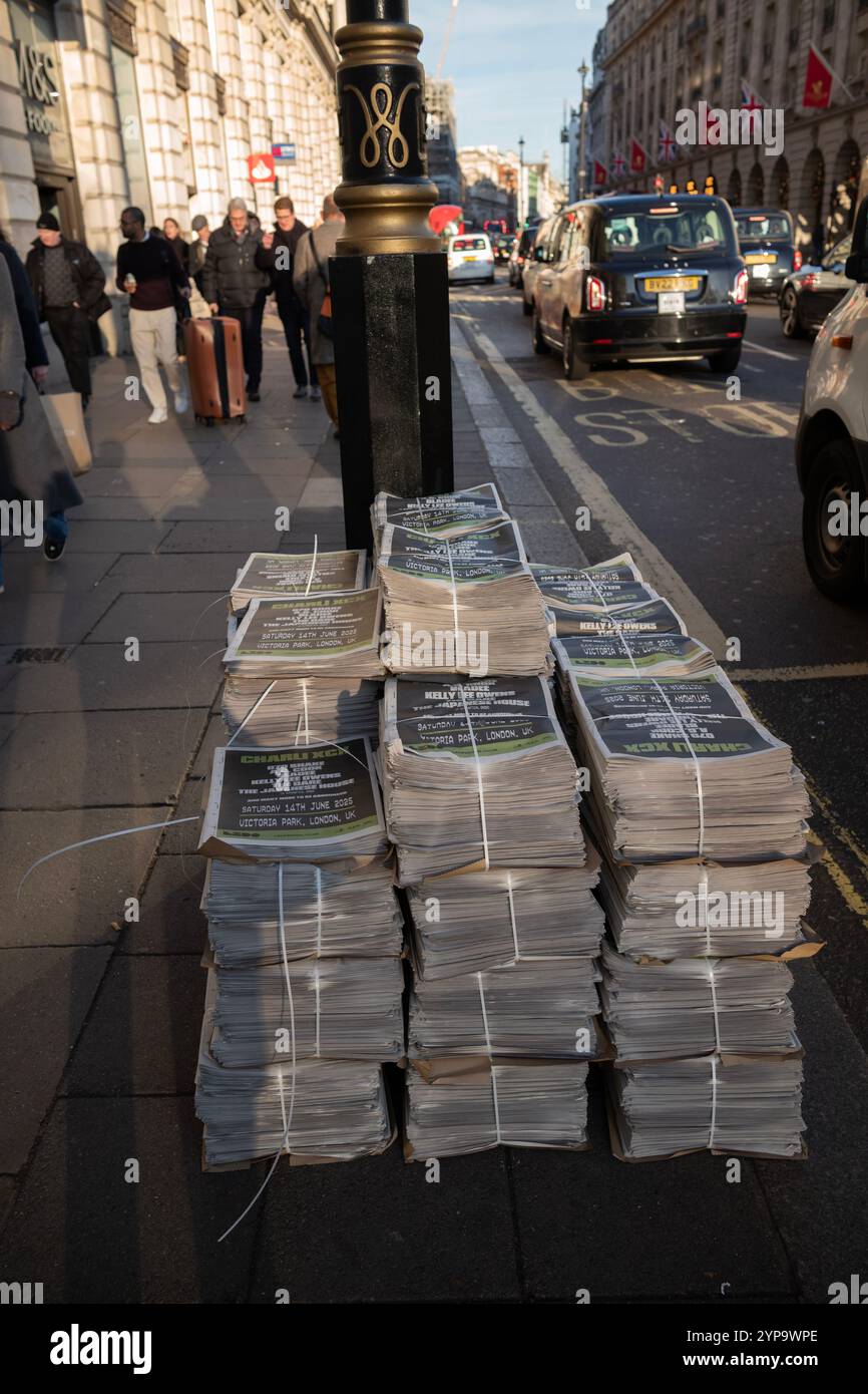 Stacks of evening newspapers stand on the street along Piccadilly ...