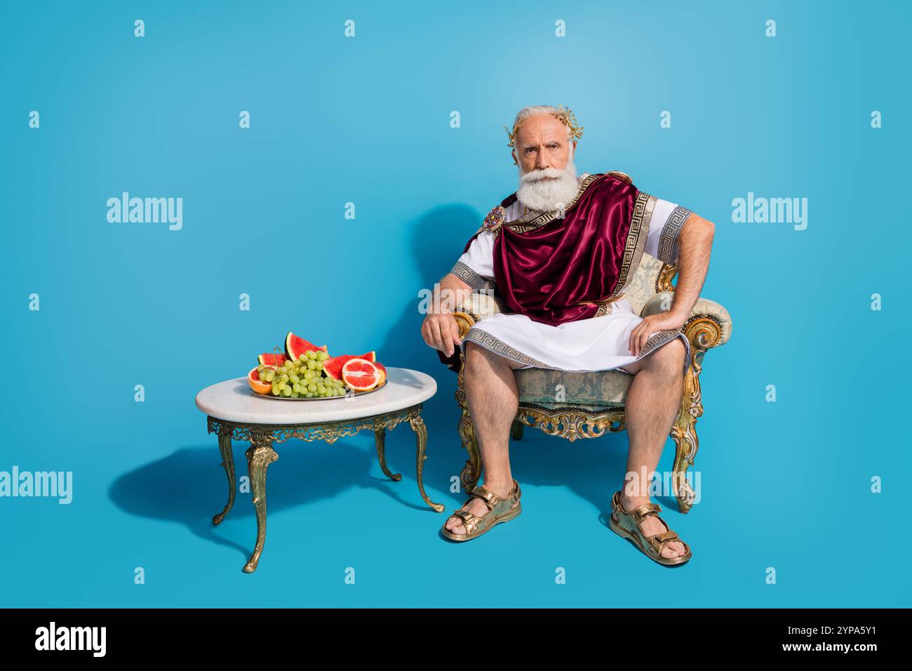Full body portrait of theater performer wear emperor costume sit throne ...