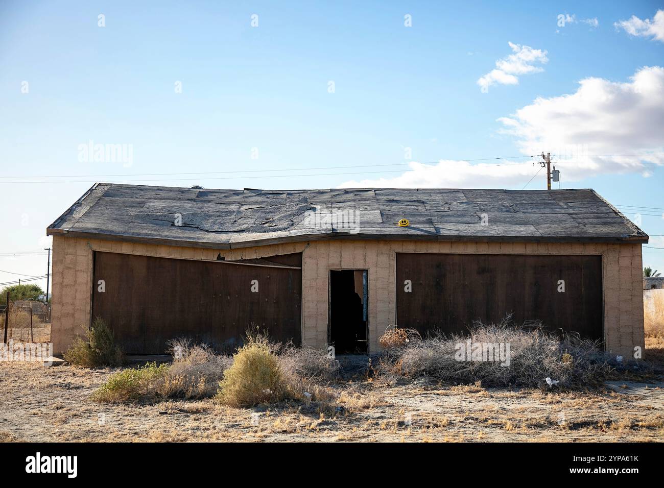 Abandoned garage with a worn roof in a dry, desolate area Stock Photo ...