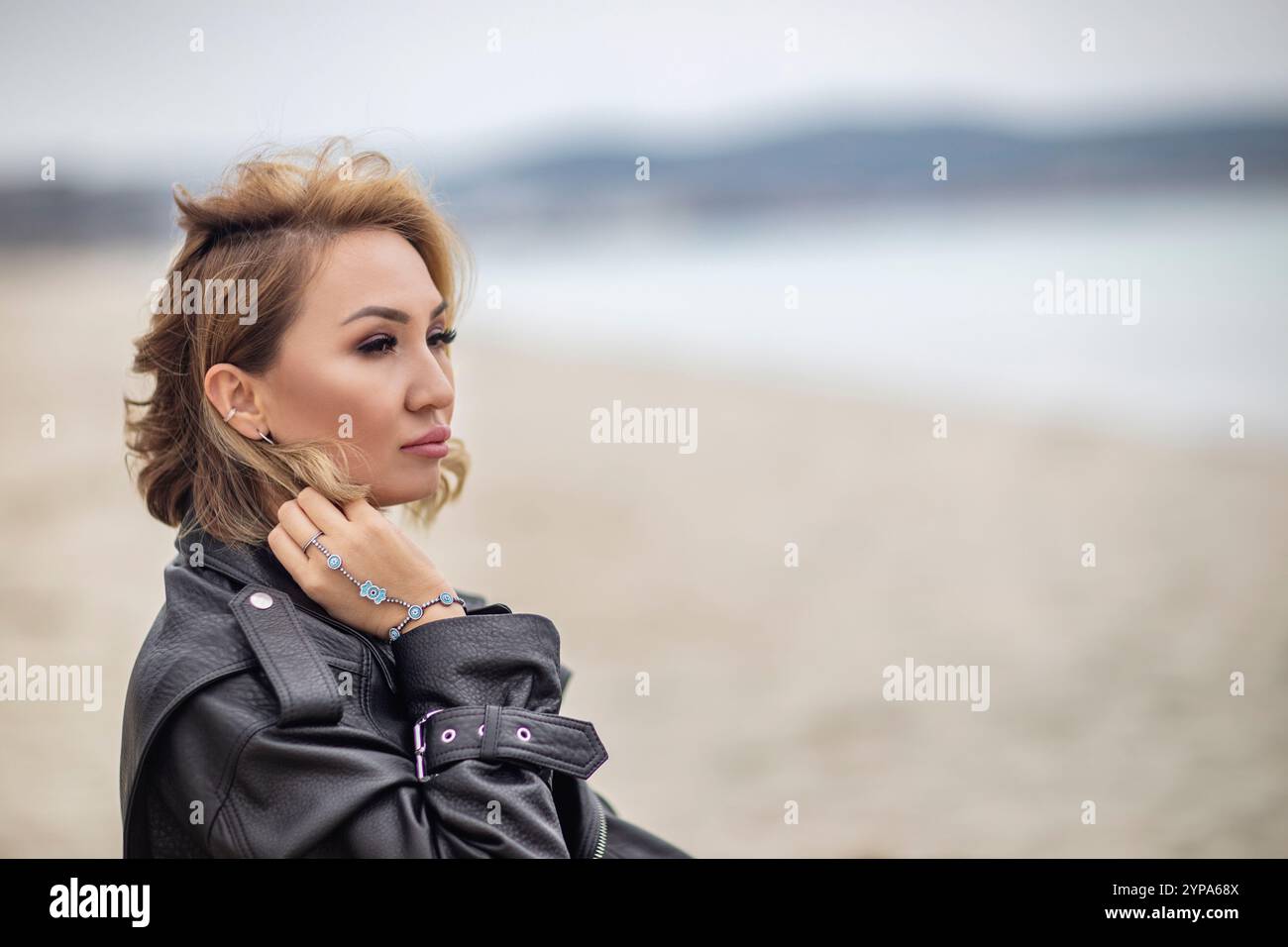 Young woman looking forward by the sea in a windy weather Stock Photo ...