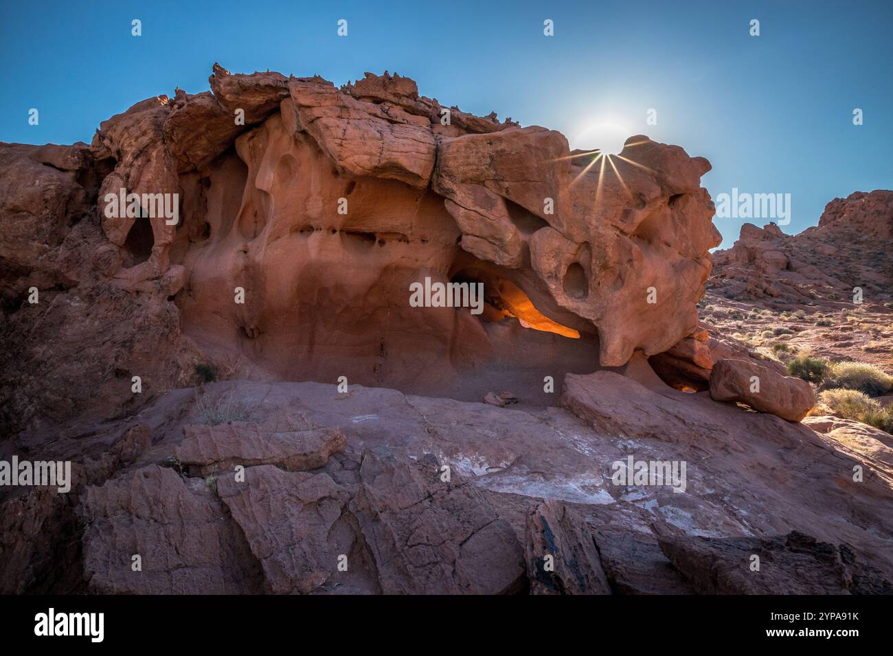 Sunburst on a unique sandstone rock formation with warm glow seen ...