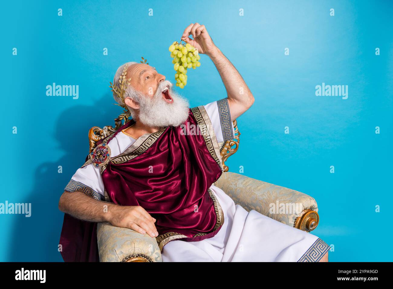 Photo of roman politician warlord costume man sit throne eat grape ...