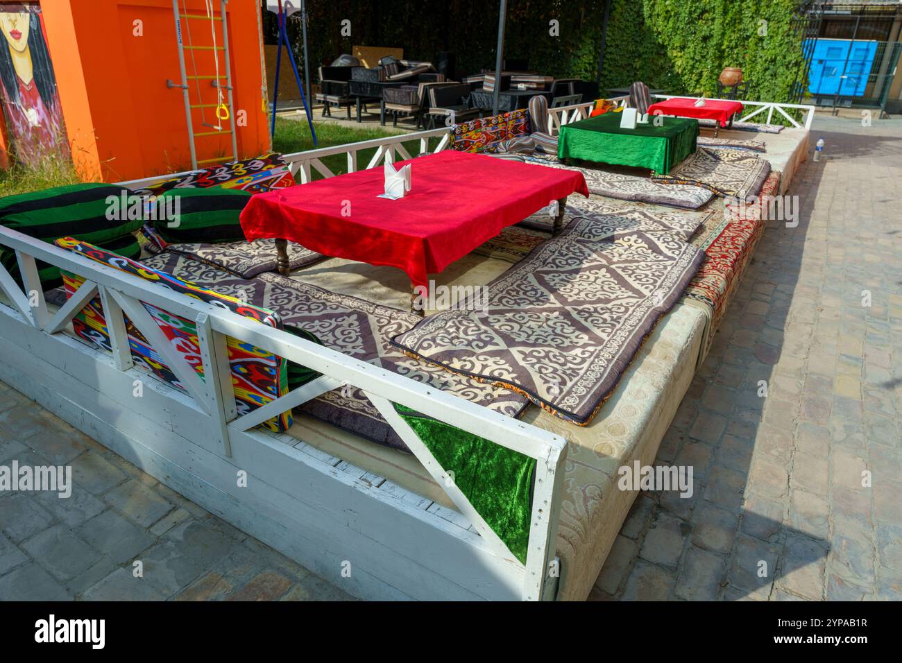A patio with a table and chairs, and a rug on the ground Stock Photo ...