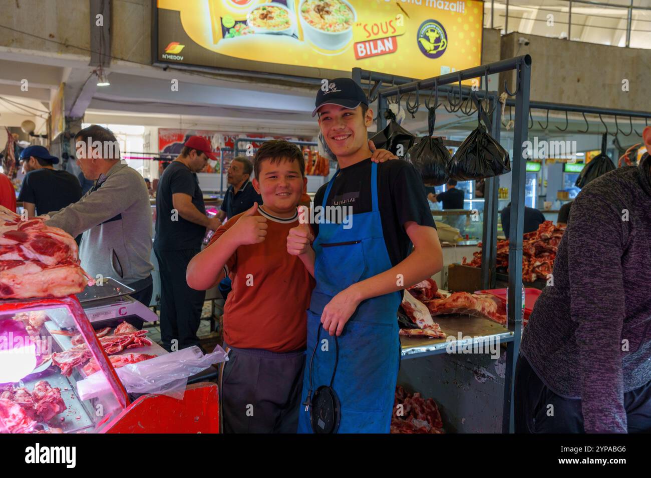 Two young men pose for a picture in front of a meat market Stock Photo ...
